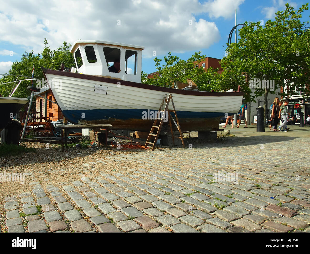 A small fishing boat on land with a step ladder beside it for access ...