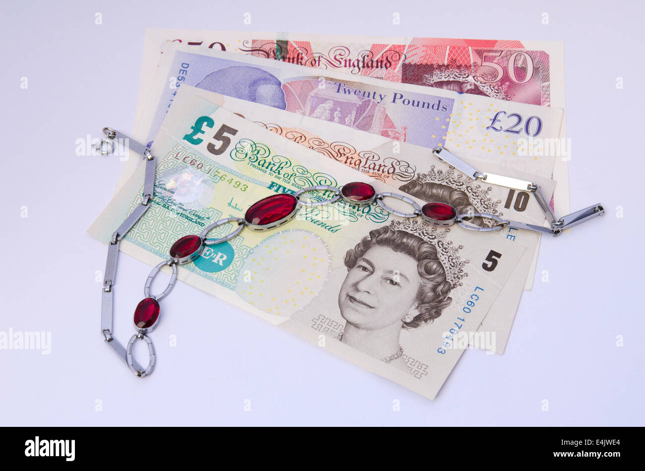 British pound notes with red stone necklace on white background Stock ...