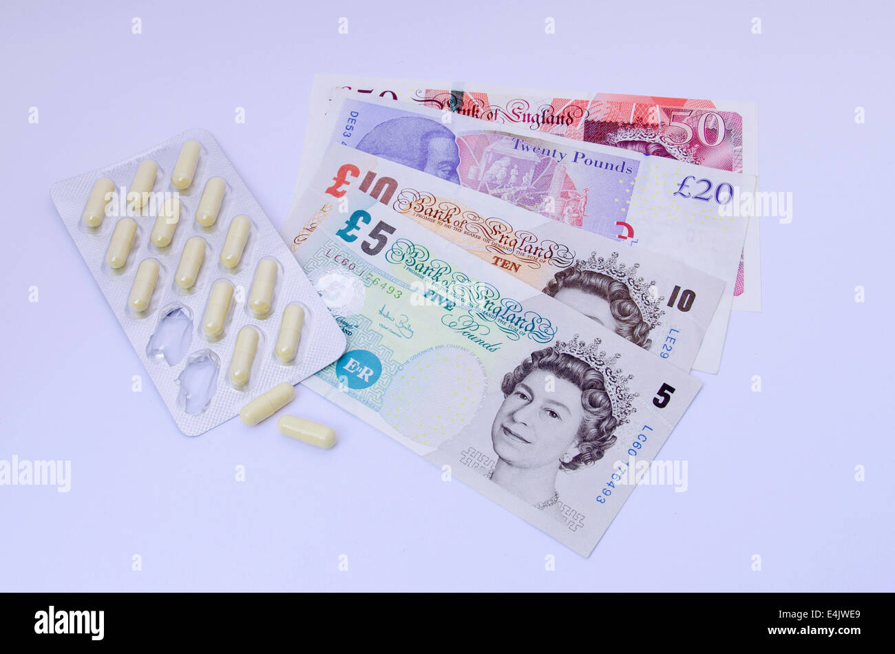 British pound notes with pills on white background Stock Photo - Alamy