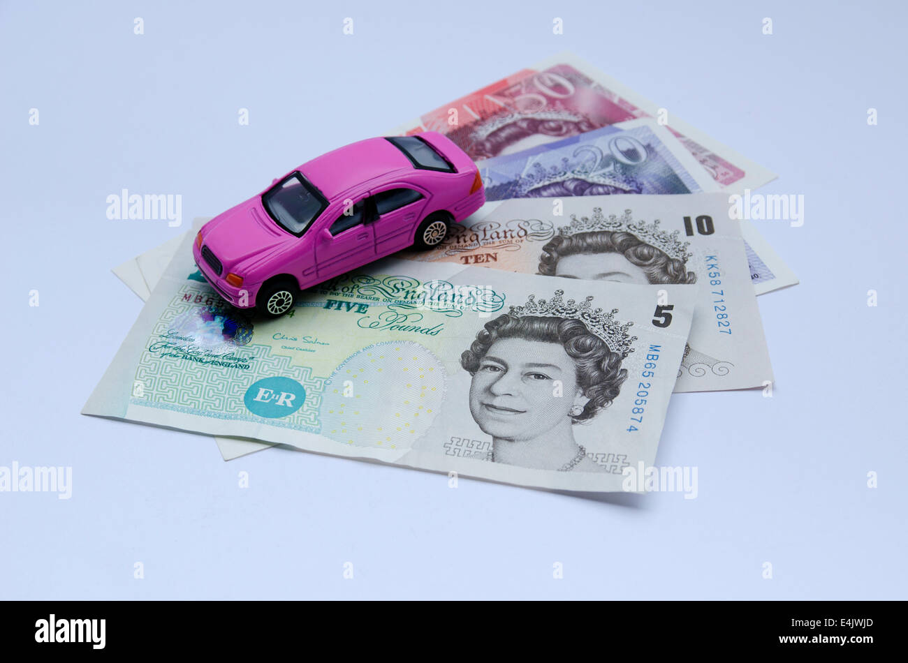 Pink toy car with pound notes on white backgorund Stock Photo - Alamy