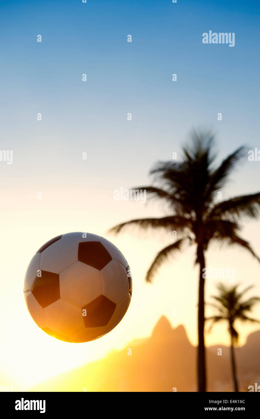 Soccer ball football flying in the golden sunset sky above Rio de ...