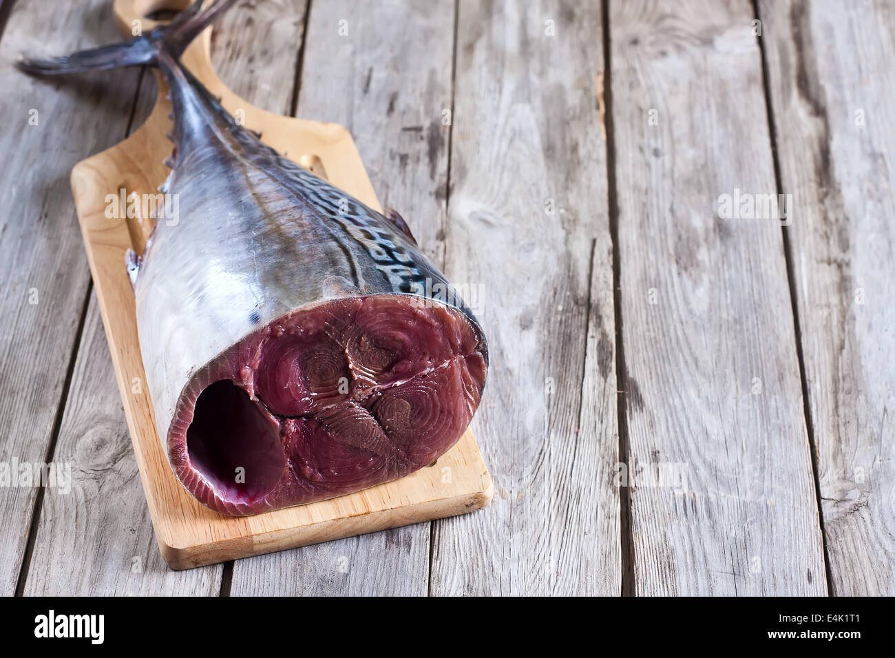 Fresh raw tuna tail on wooden board. Selective focus. Copy space ...