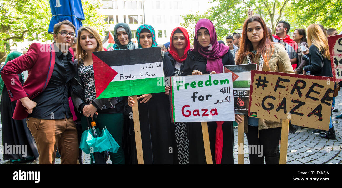 Severel young protesters hold protest signs in their hands which read ...