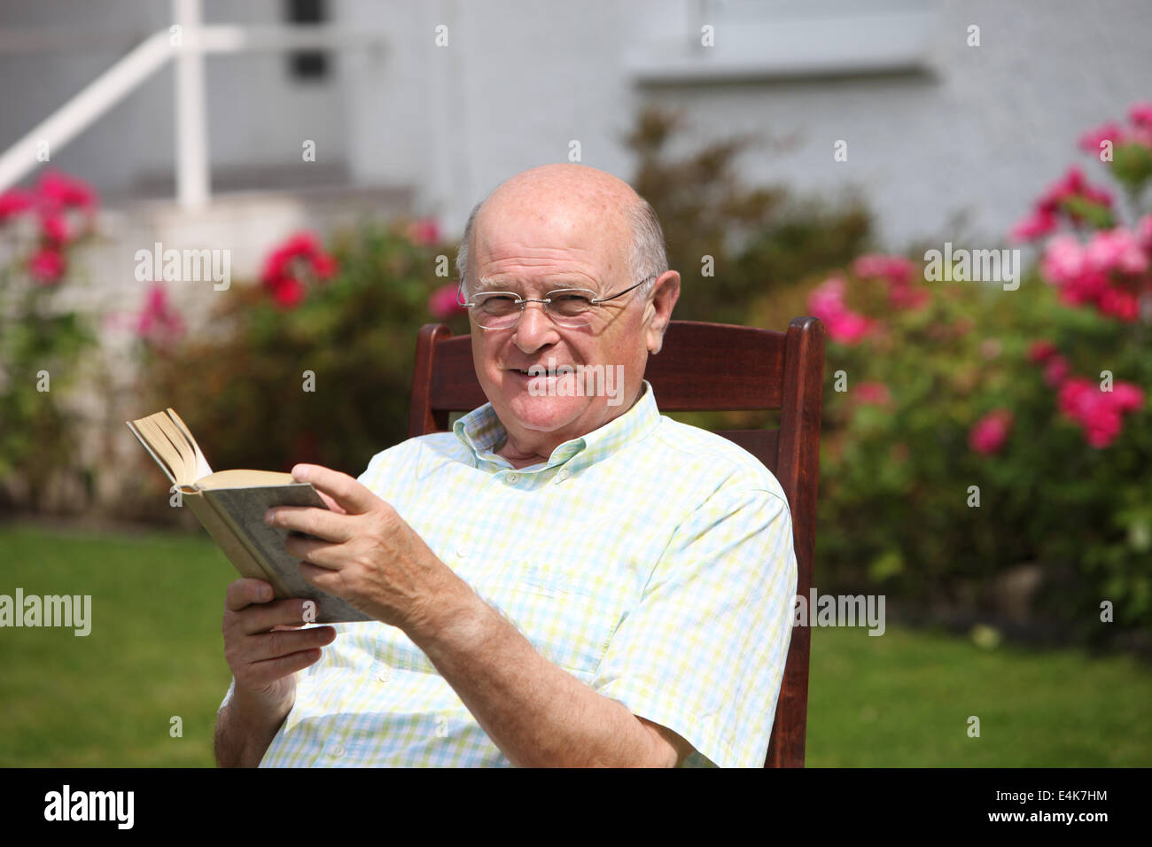 Elderly man reading a book in sunshine Stock Photo - Alamy