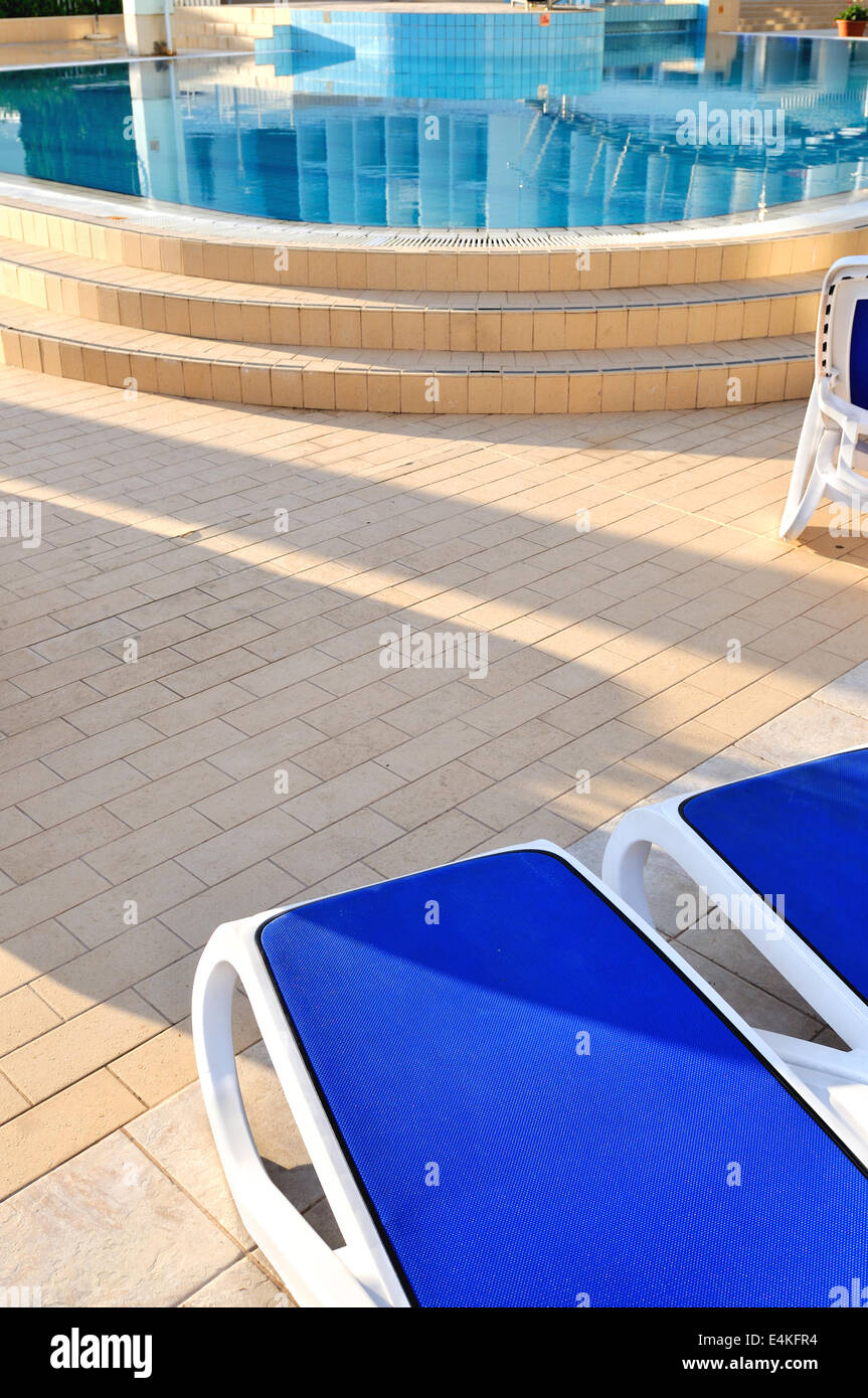 Empty chairs by the pool of hotel Stock Photo - Alamy