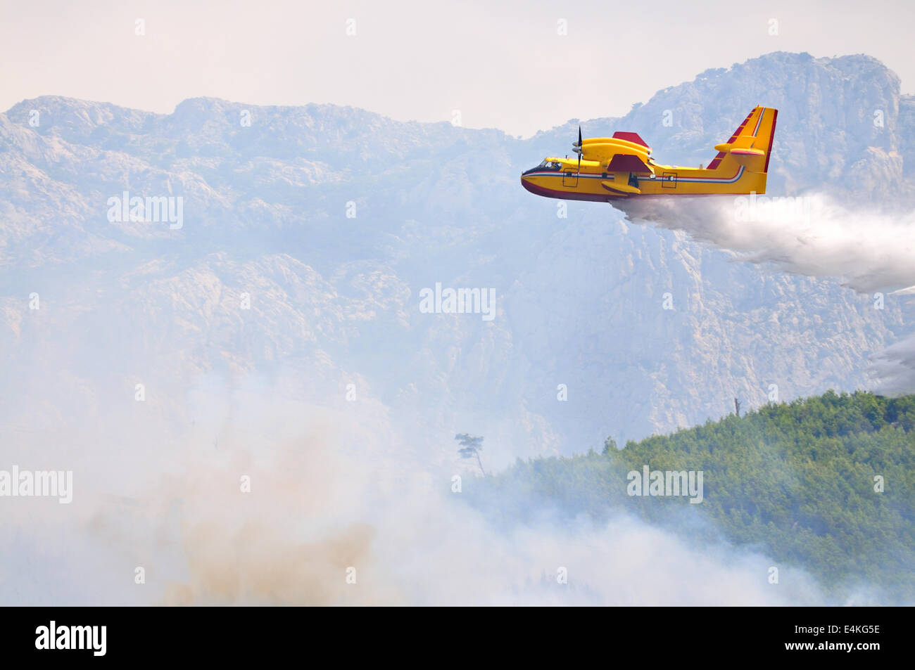 Airplane droping water on fire Stock Photo - Alamy