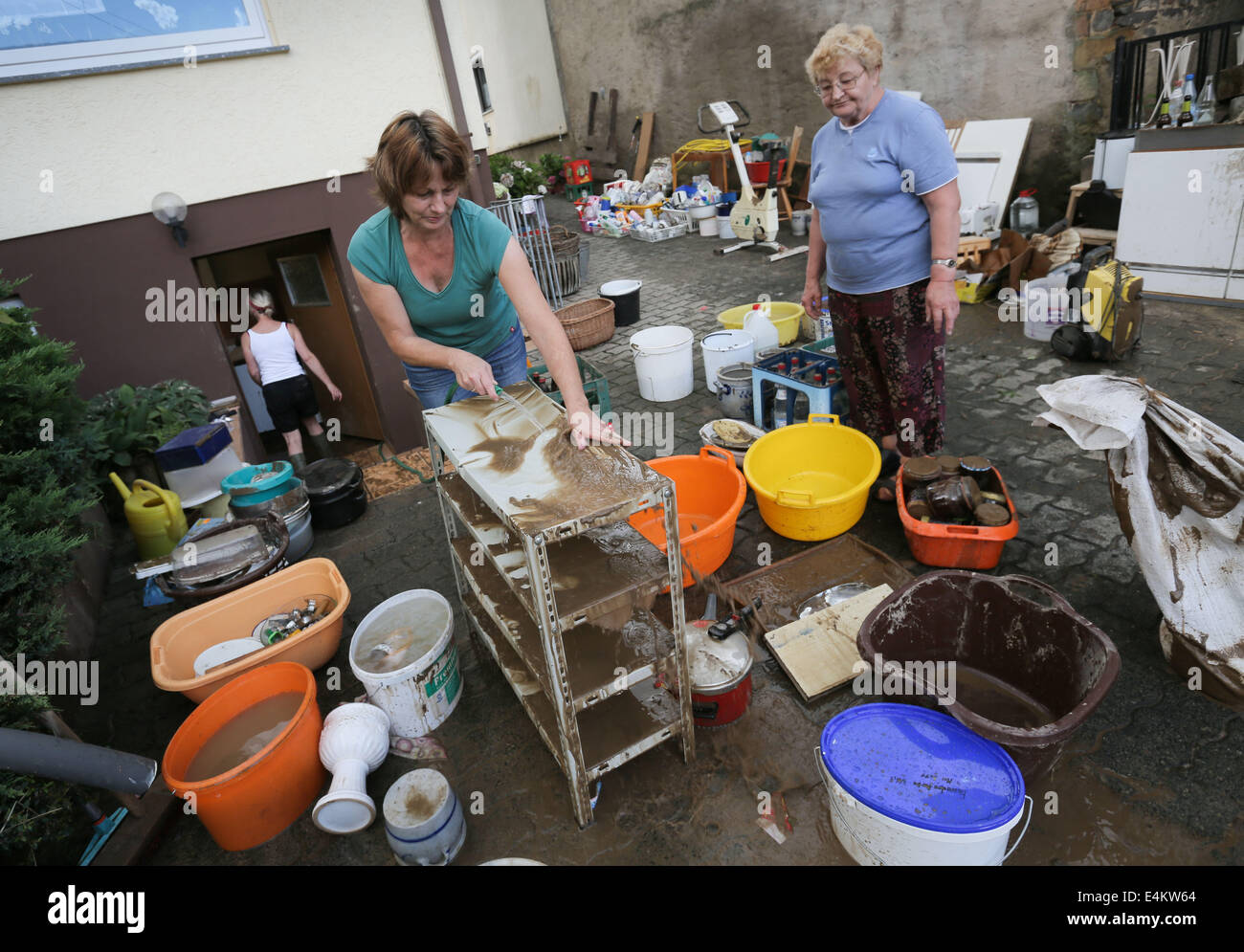 Members of the Nies family clear out their flooded cellar in ...