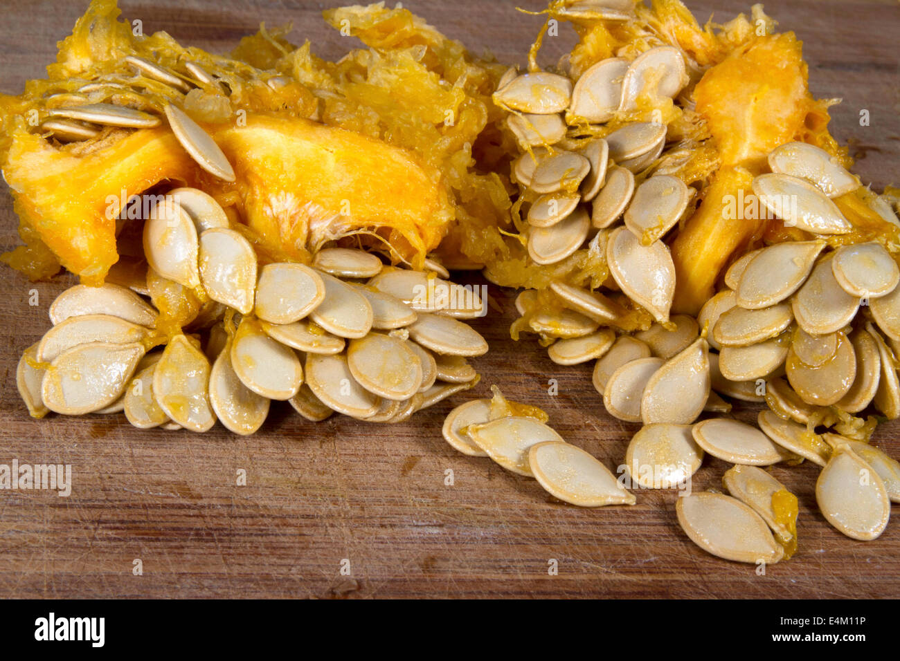 Raw squash seed and meat on wooden cutting board before roasting Stock ...