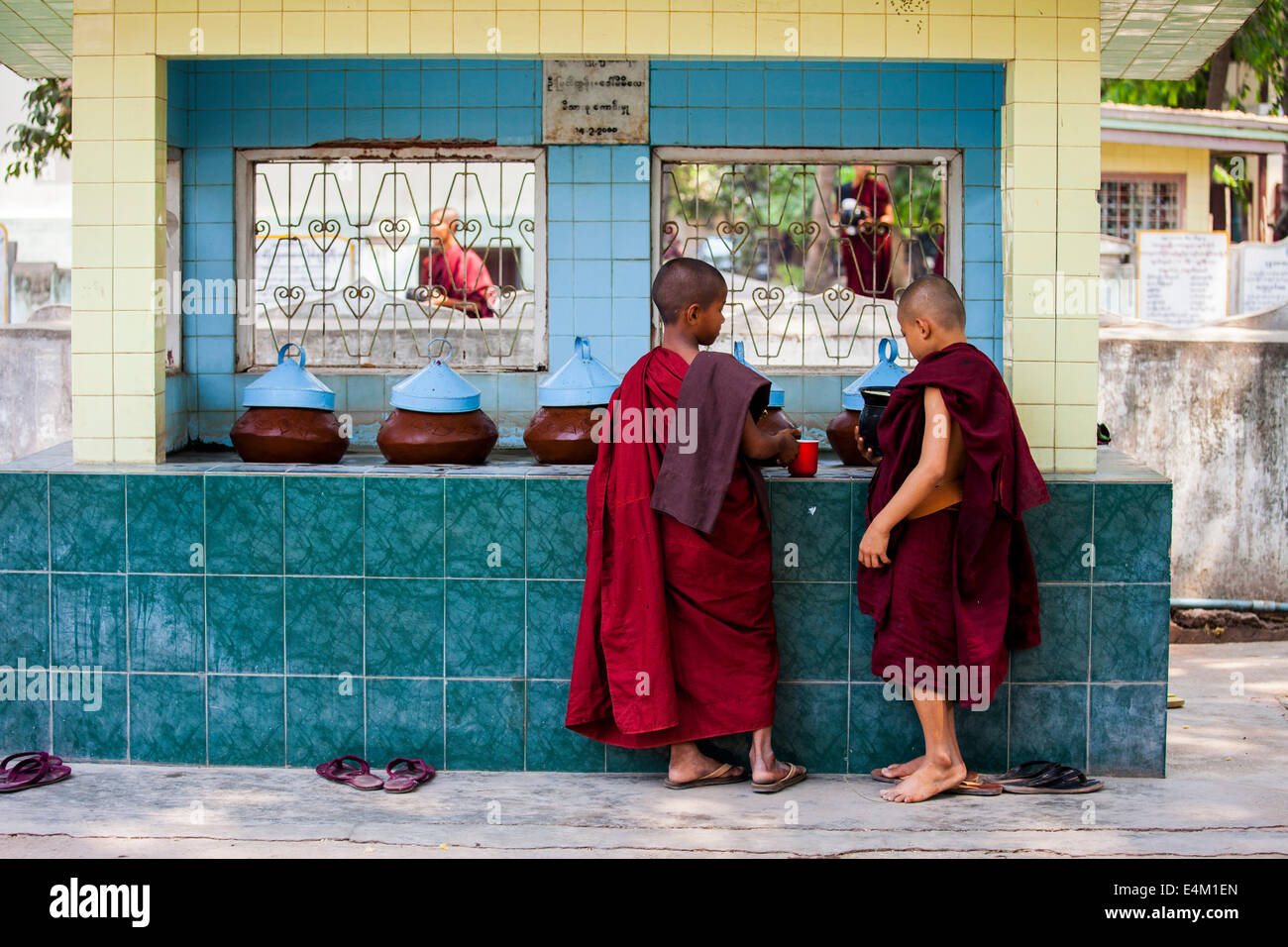Monks take a break and drink some water and kiosk that contains two big ...