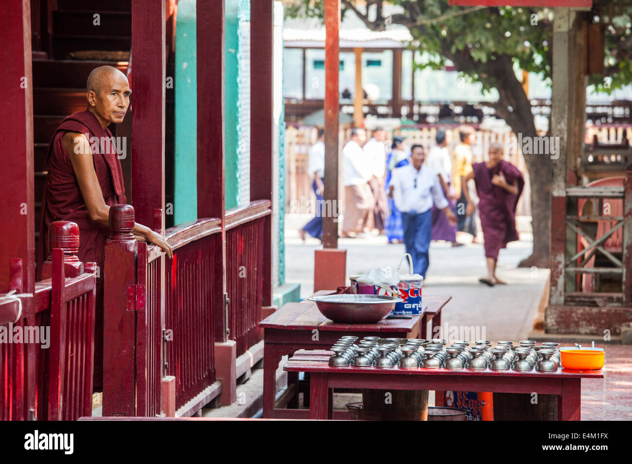 A senior monk waits for younger monks to enter the dining area of a ...