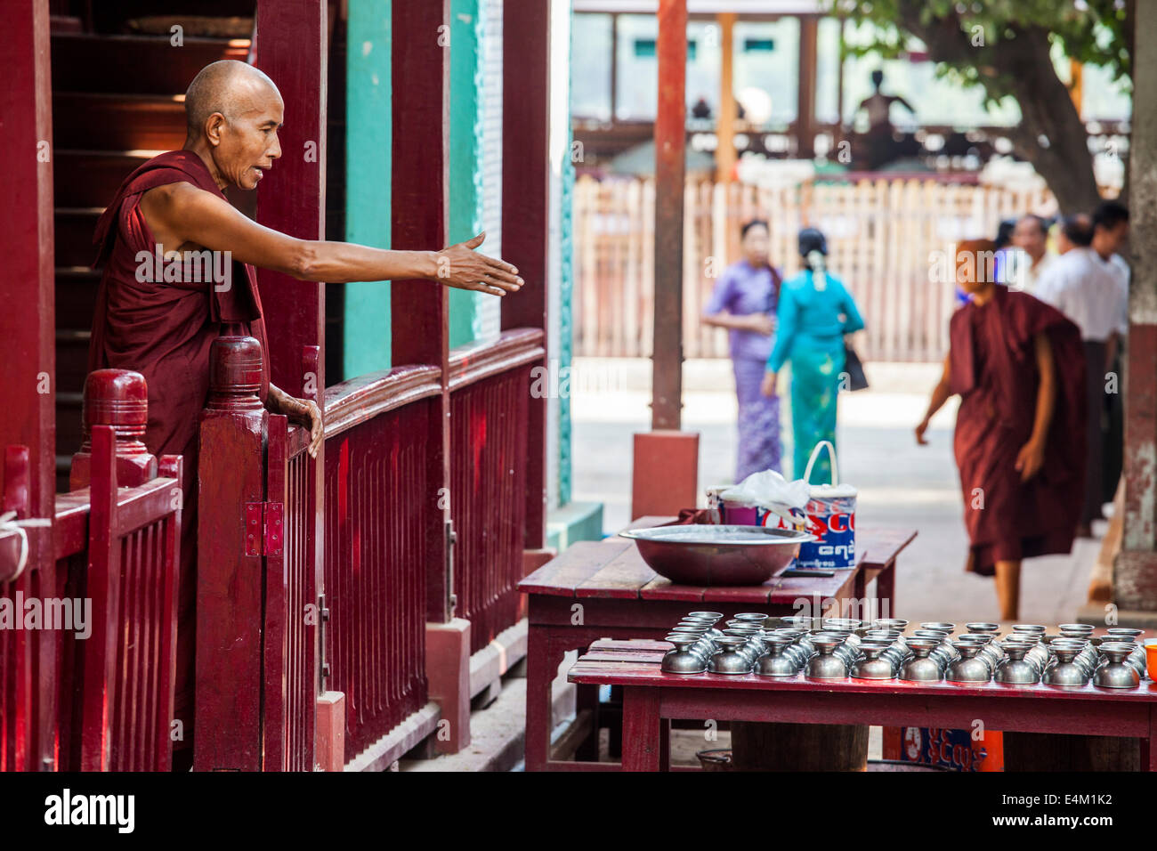 A senior monk waits for younger monks to enter the dining area of a ...