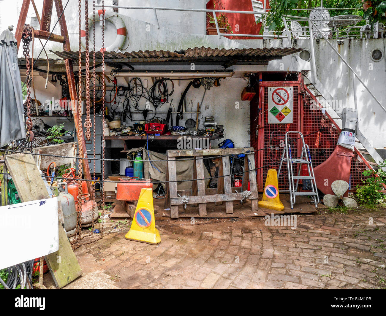 Workshop of working boatyard with rusty chains, tools, gas cylinders on ...