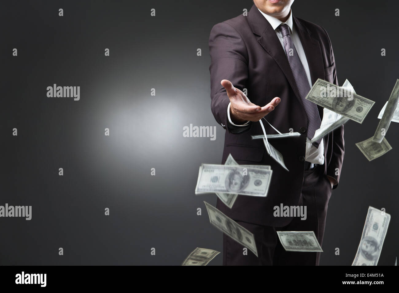 Handsome young man throwing money over dark background Stock Photo - Alamy