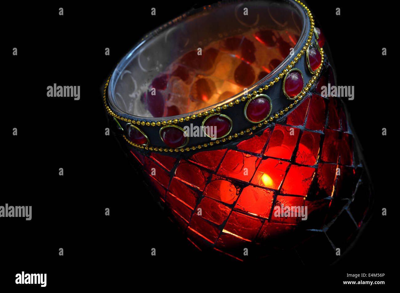 burning tea light in a red glass, close up, isolated on black ...