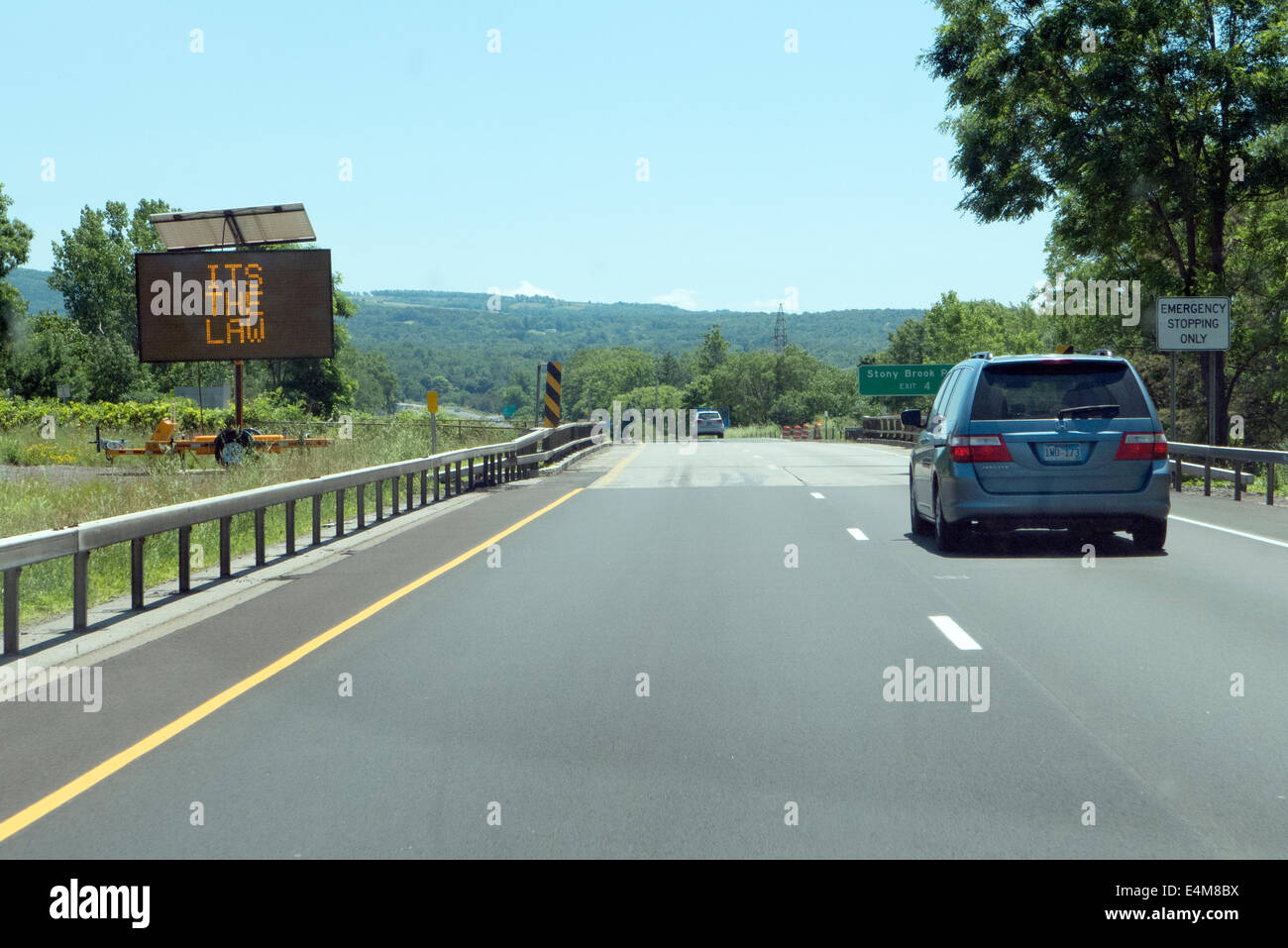 Car approaching sign on highway Stock Photo - Alamy