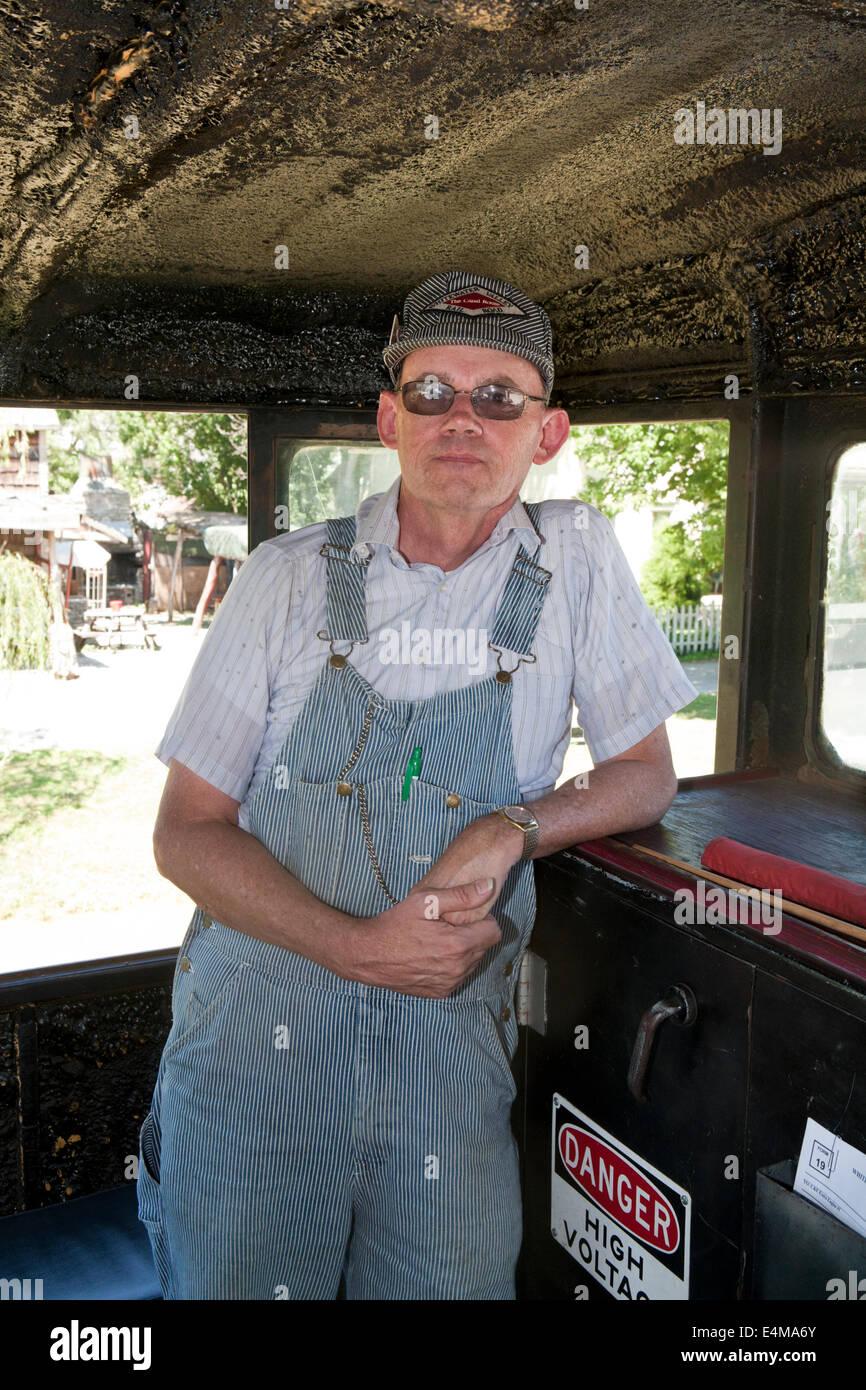 Man dressed as a railroad engineer in the cab of a switcher locomotive ...