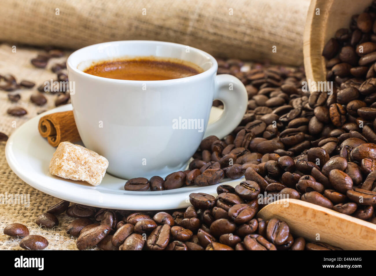 fresh espresso coffee in white cup with lump sugar, cinnamon and ...