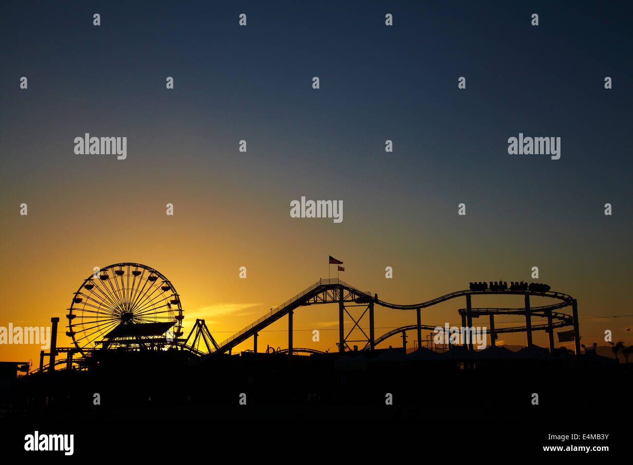 Ferris wheel and roller coaster at sunset, Pacific Park, Santa Monica ...