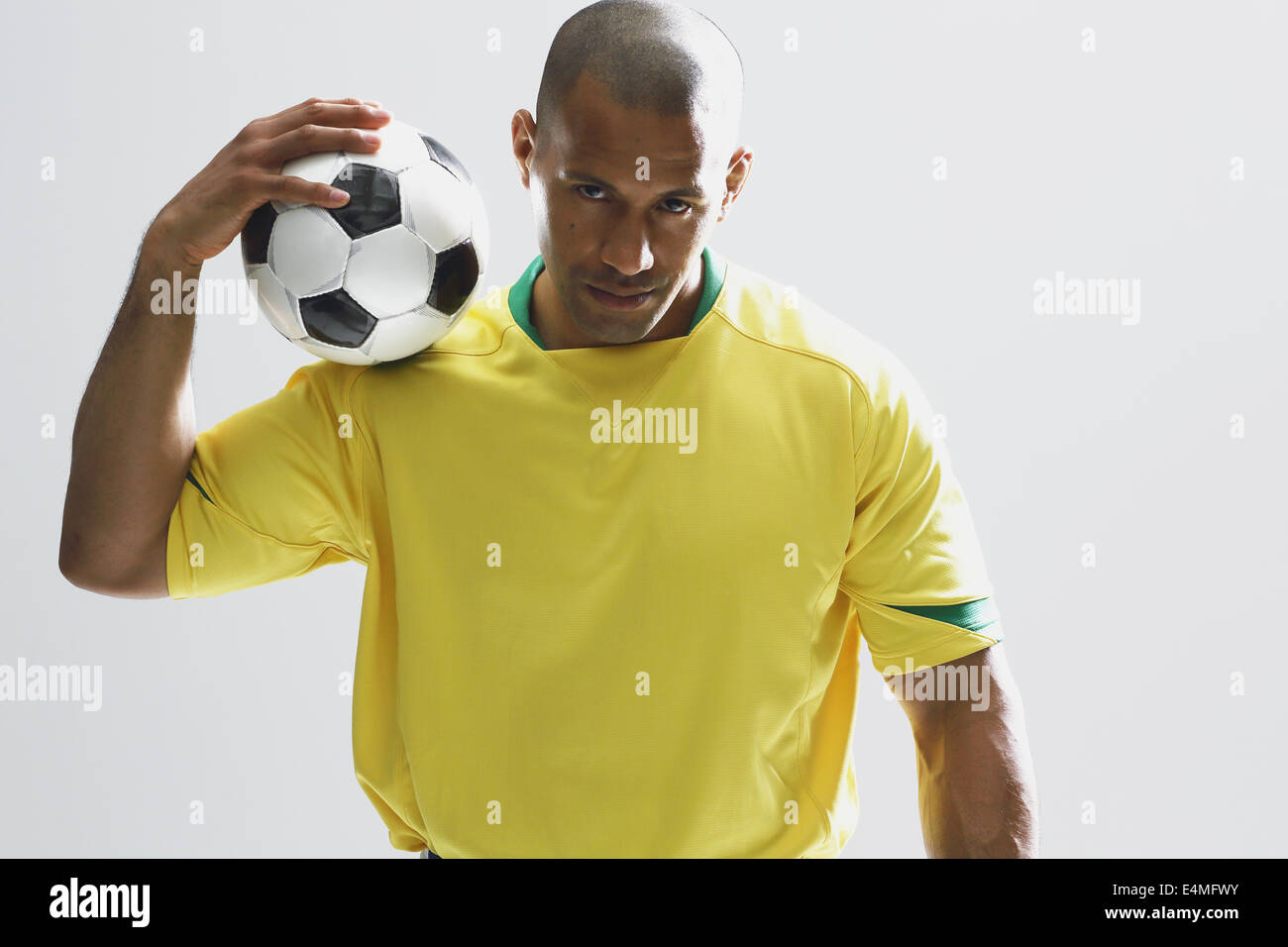 Football player in a yellow uniform standing against white background ...