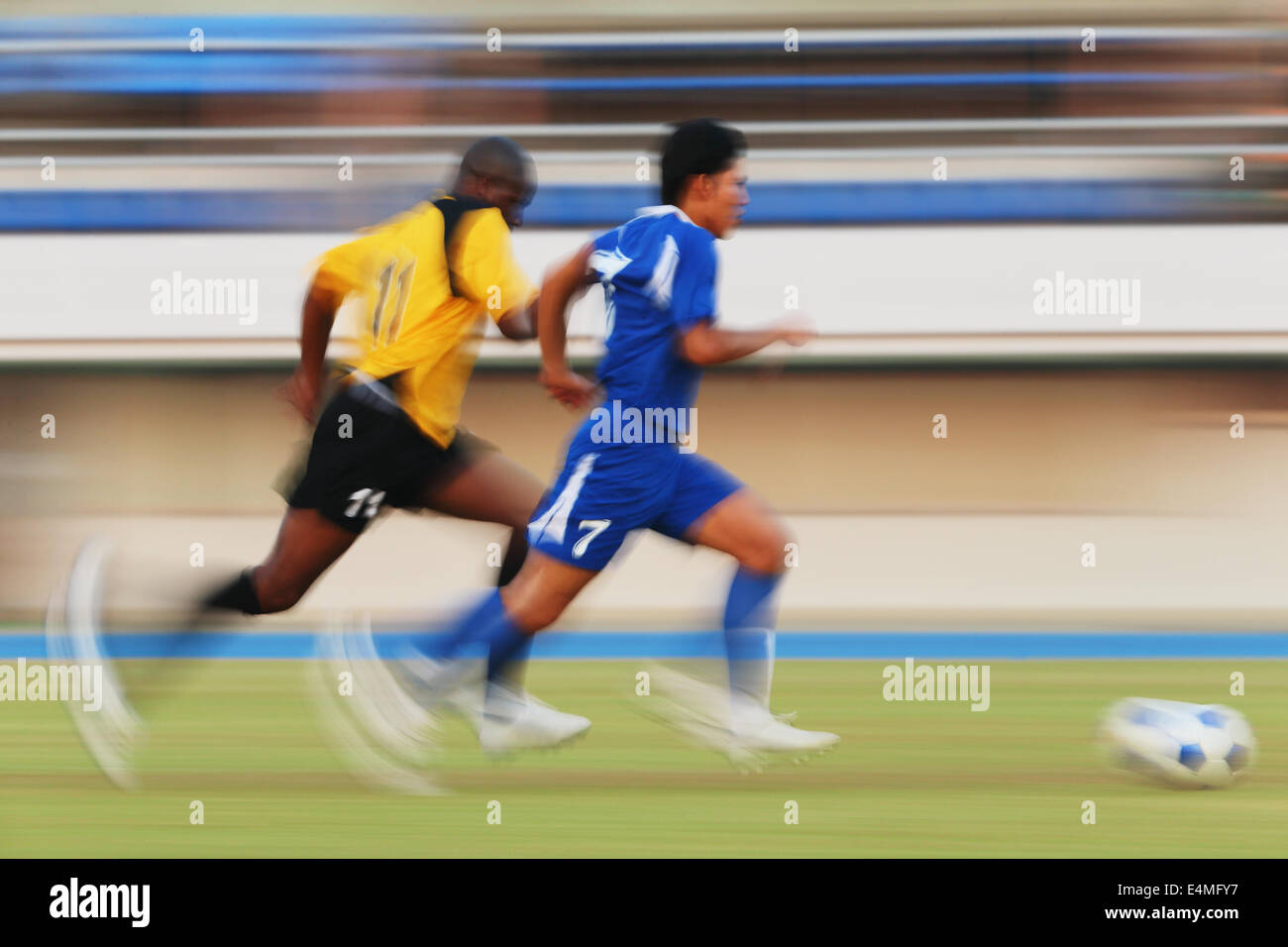 Football players running with ball Stock Photo - Alamy
