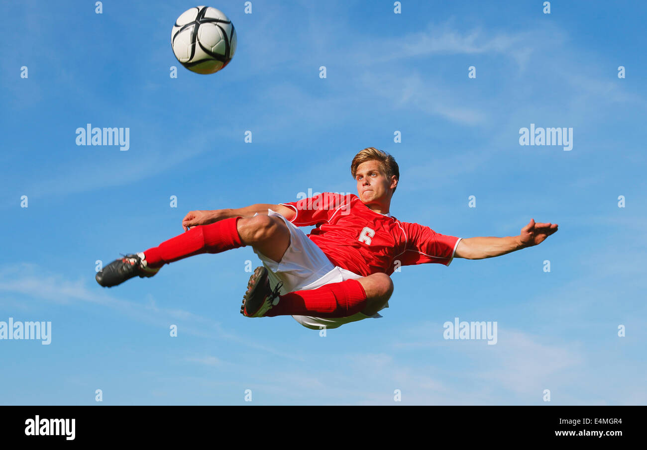 Soccer Player Kicking The Ball In Mid-Air Stock Photo - Alamy