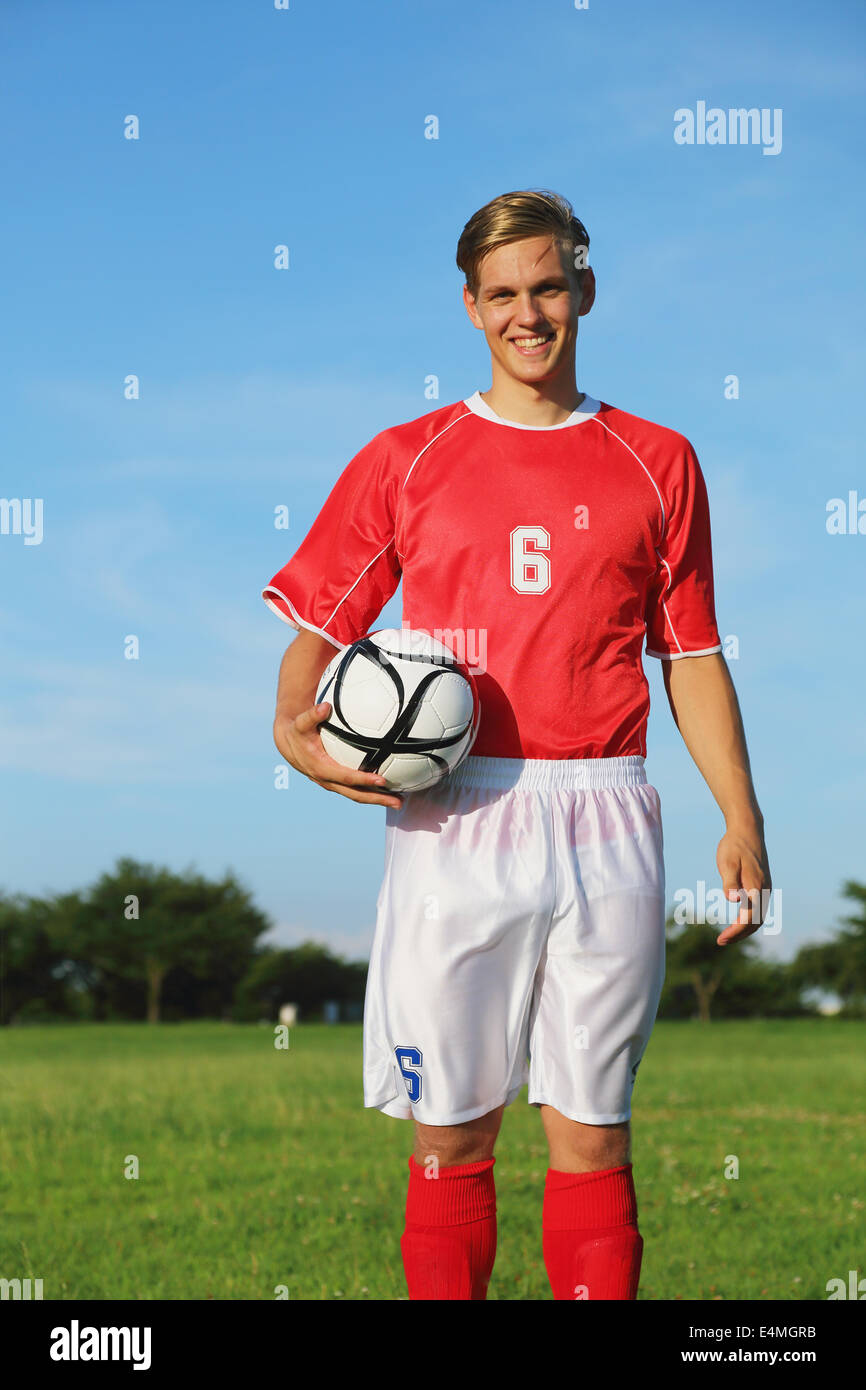 Soccer Player Standing With Ball Stock Photo - Alamy