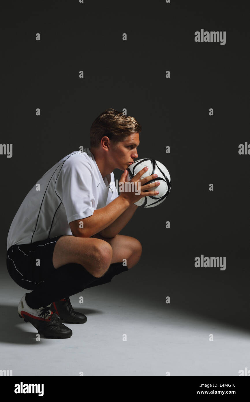 Soccer Player Crouching With Ball Stock Photo - Alamy