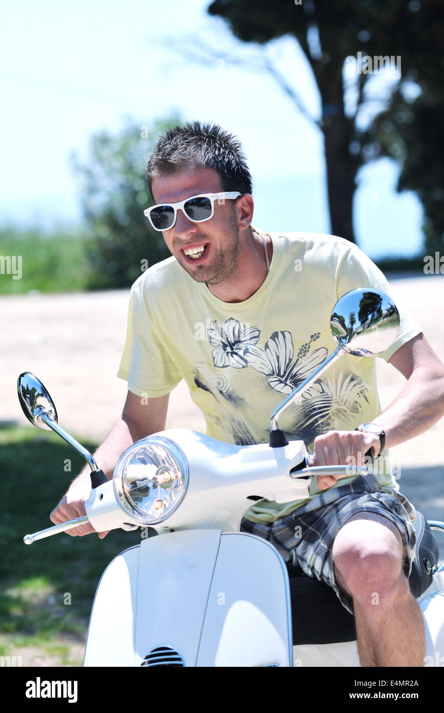 young man ride retro scooter Stock Photo - Alamy