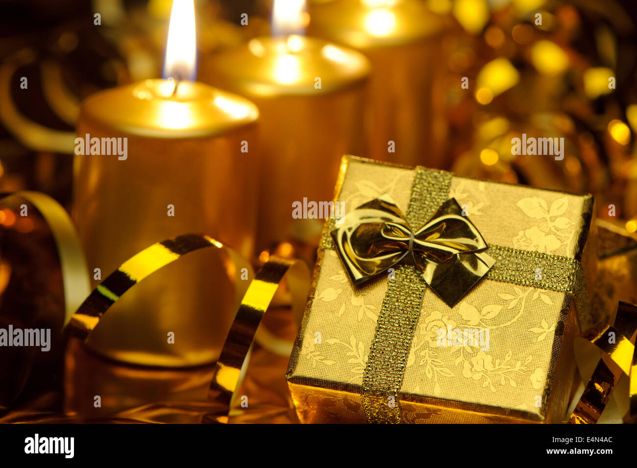 Gold christmas candles and gold gift boxes Stock Photo - Alamy