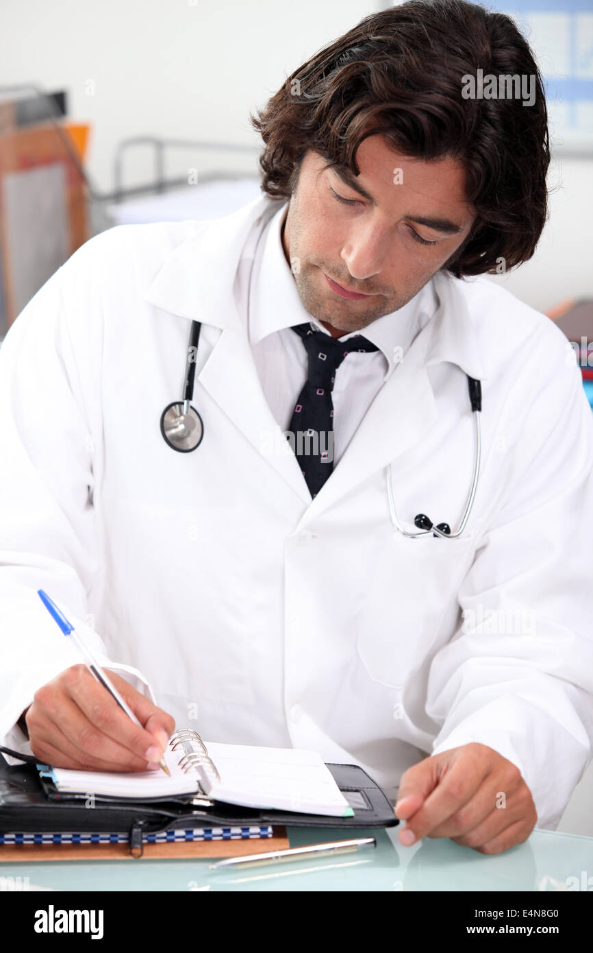 Doctor writing in diary Stock Photo - Alamy