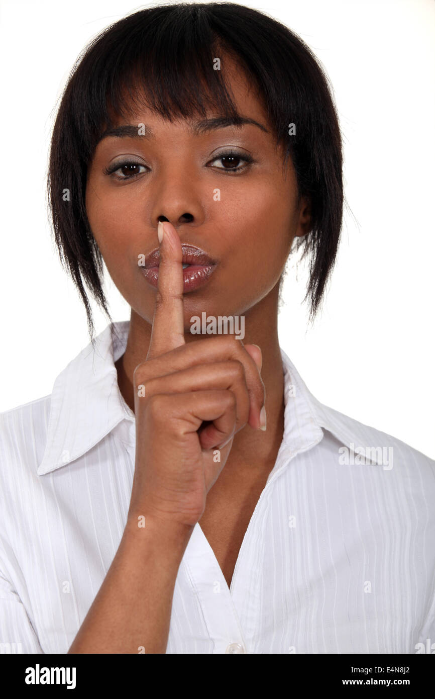 Woman holding her index finger to her lips Stock Photo - Alamy