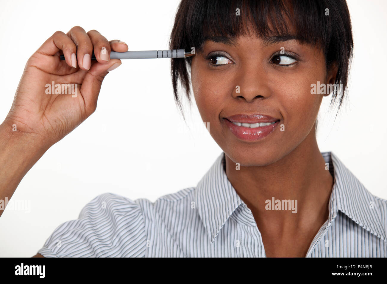 Women with pen pointing towards her temple Stock Photo - Alamy