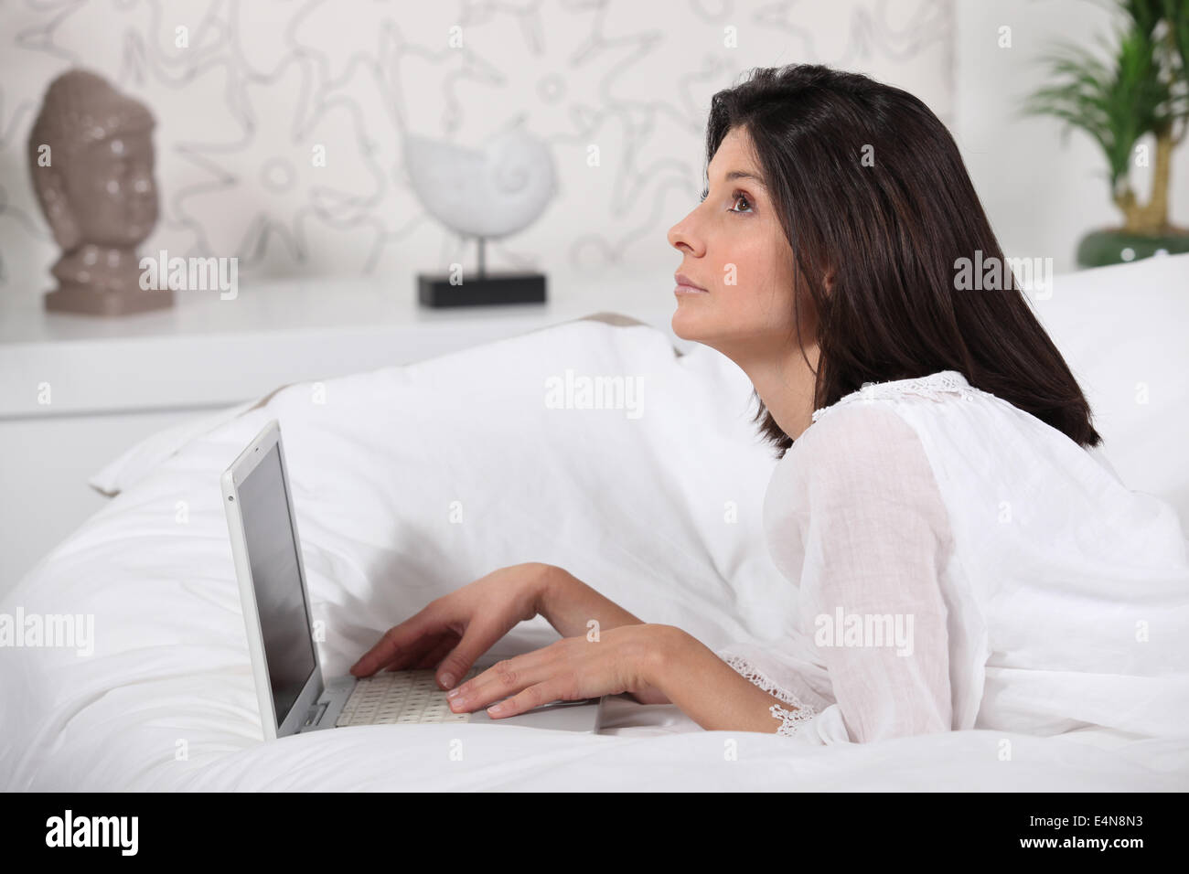 Woman using her laptop in bed Stock Photo - Alamy