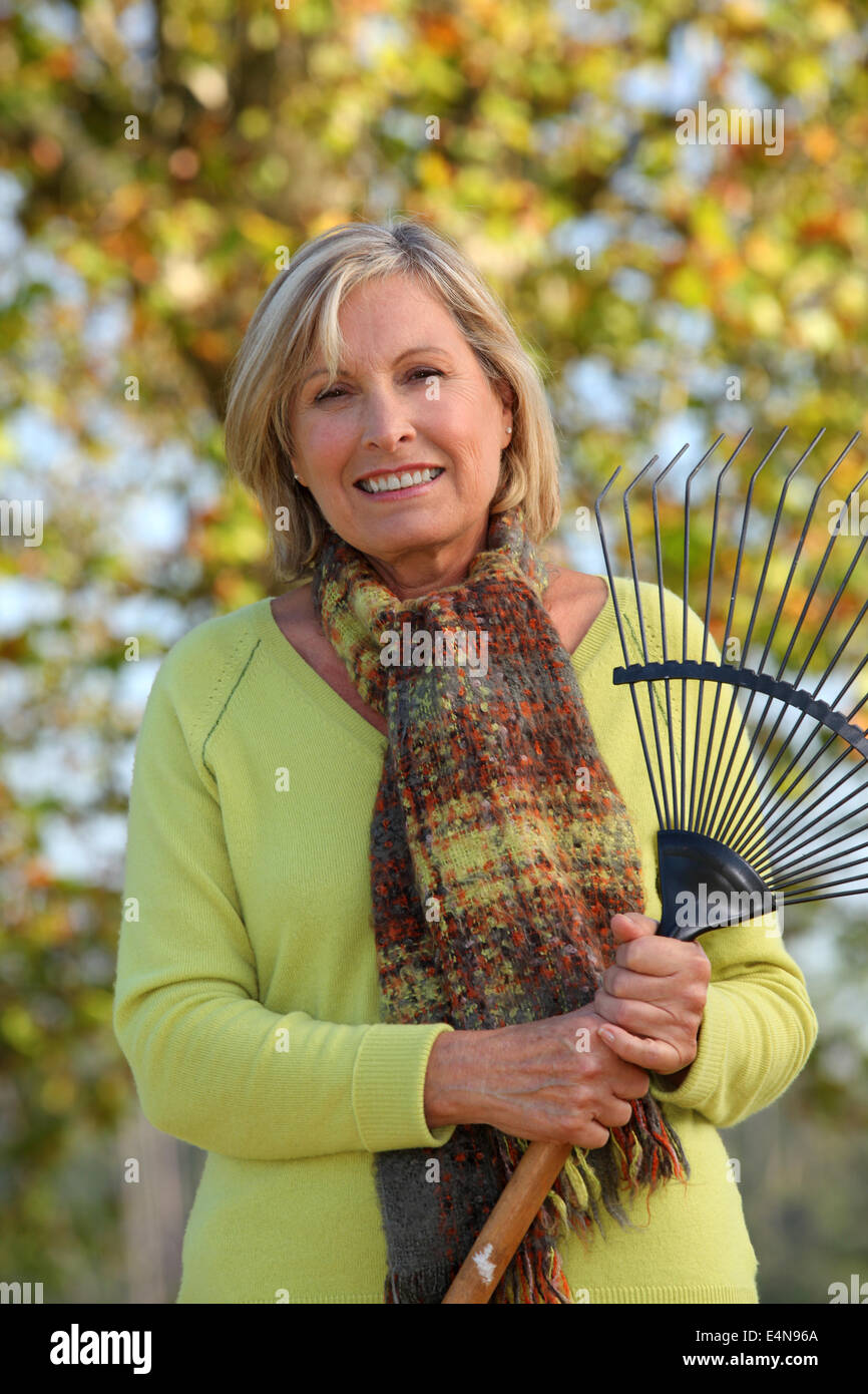 Woman raking leaves in a yard Stock Photo - Alamy