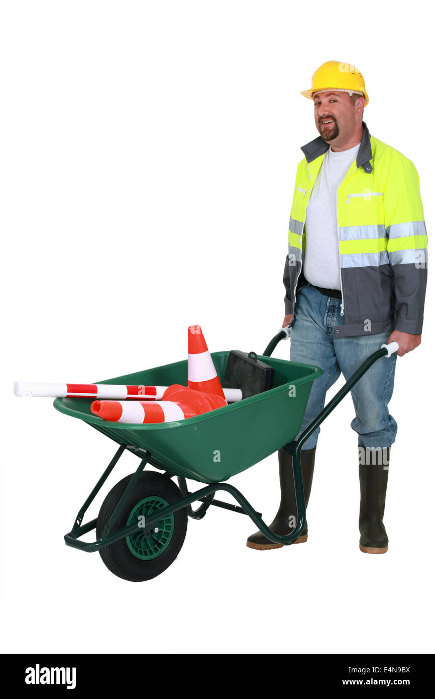 Workman pushing wheelbarrow Stock Photo - Alamy