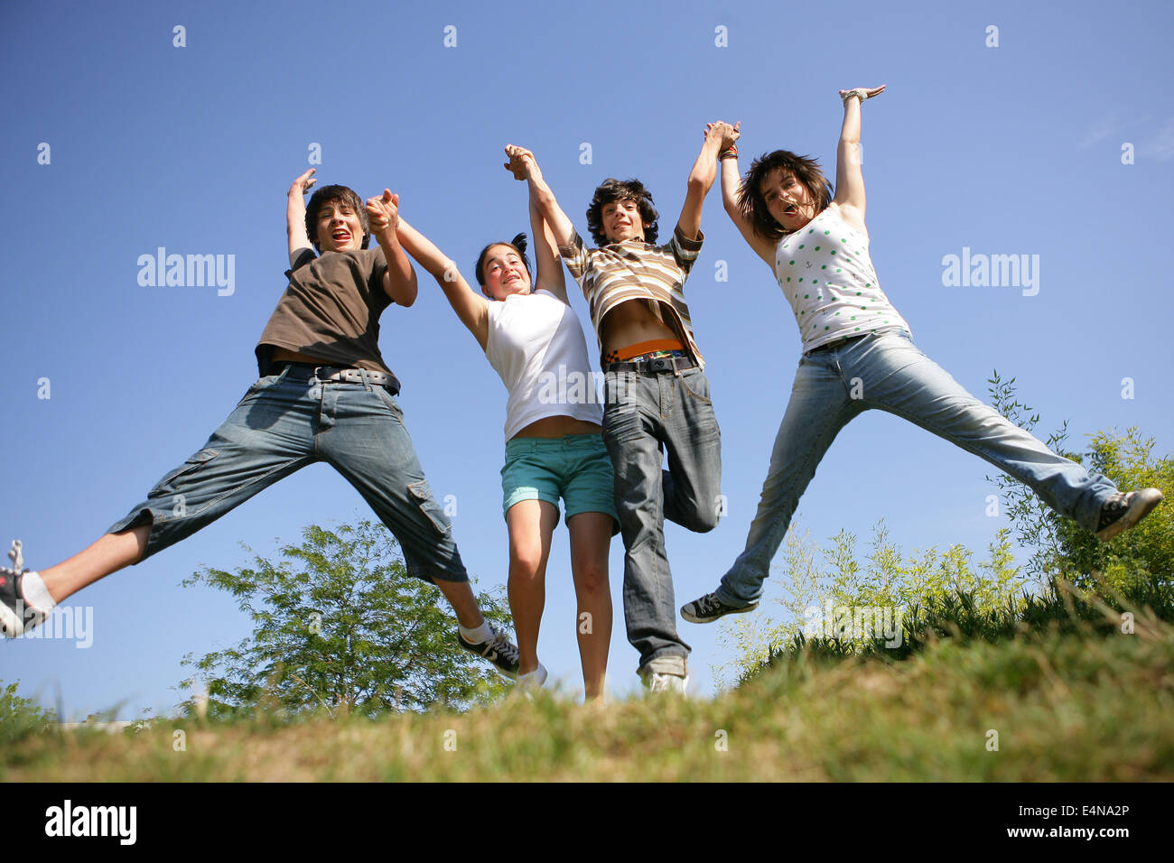 four teenagers jumping Stock Photo - Alamy