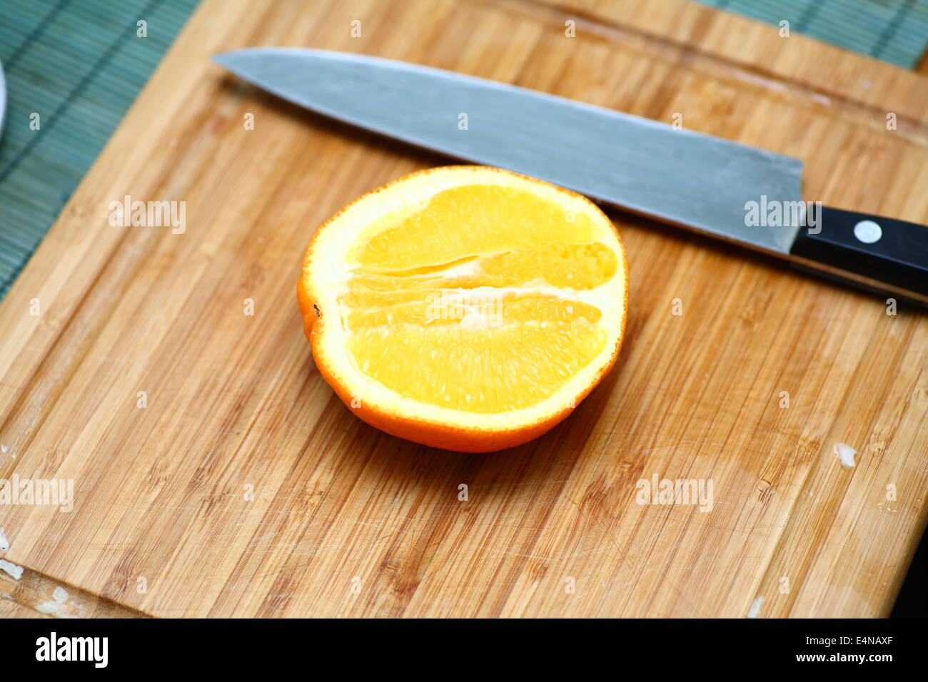 half of orange cut with knife Stock Photo - Alamy
