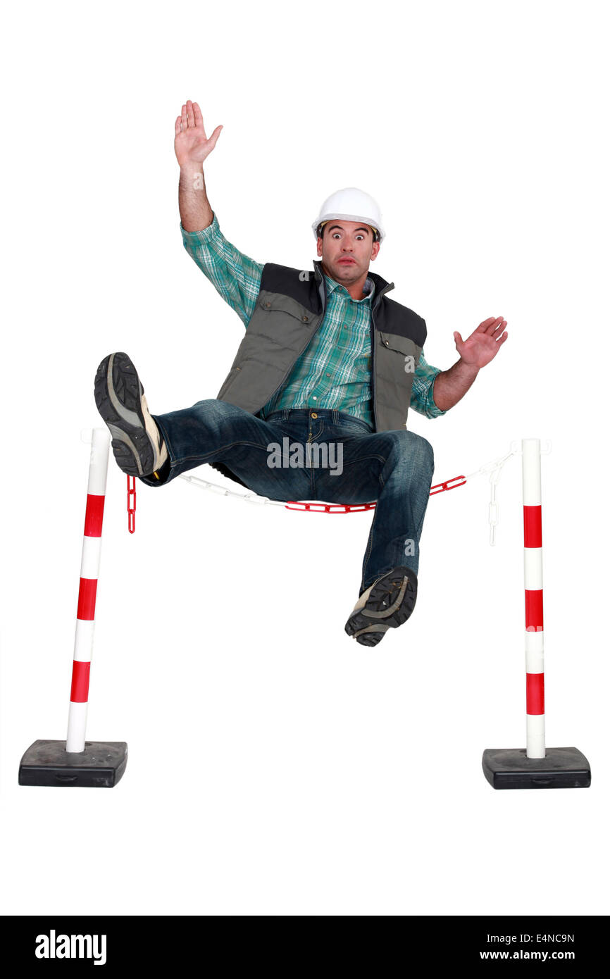 Workman falling over a safety barrier Stock Photo - Alamy