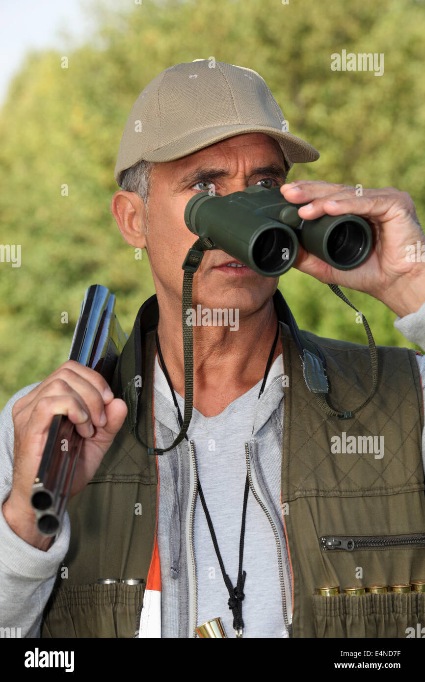 Hunter looking through binoculars Stock Photo - Alamy