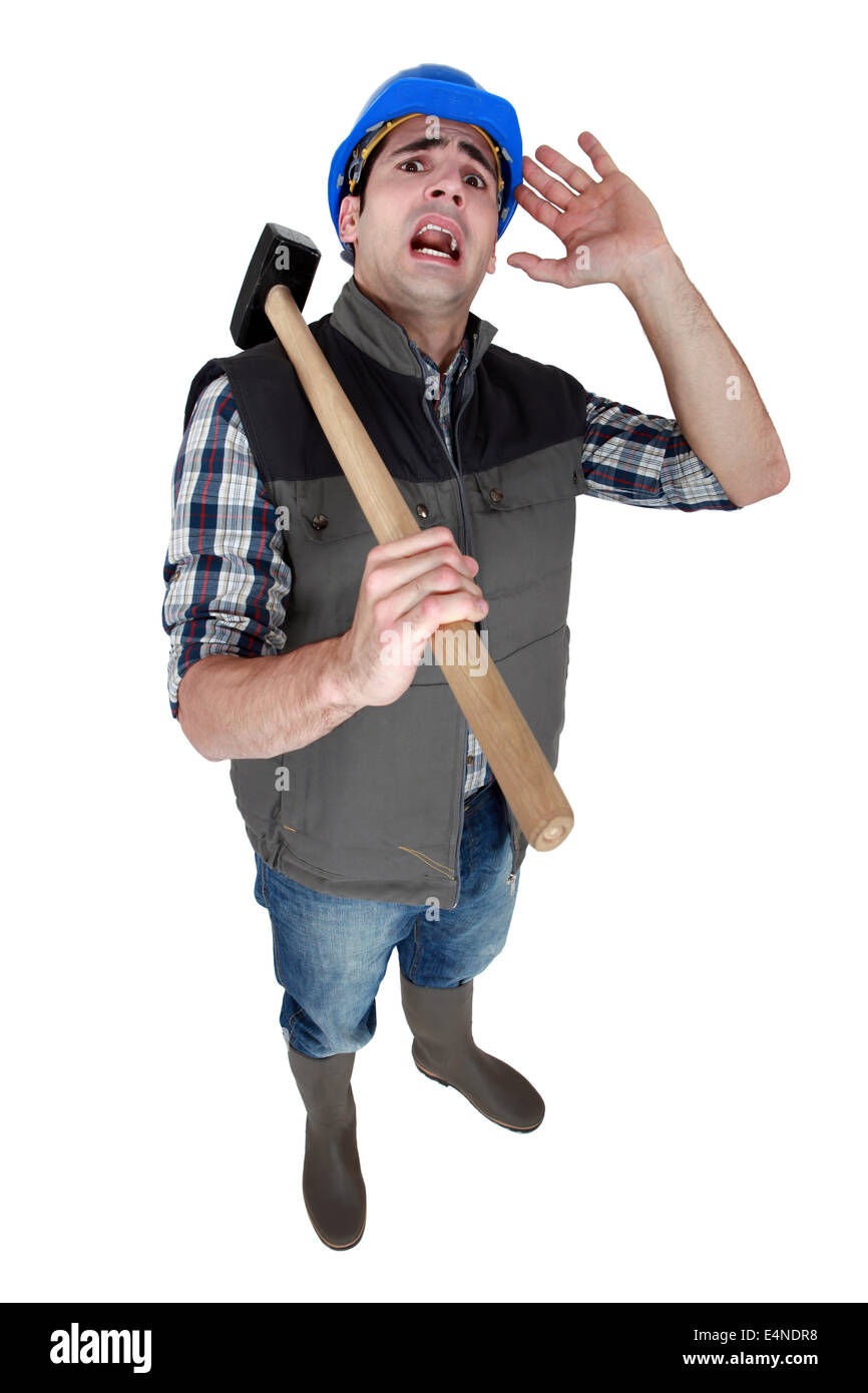 Scared builder cowering away from camera Stock Photo - Alamy