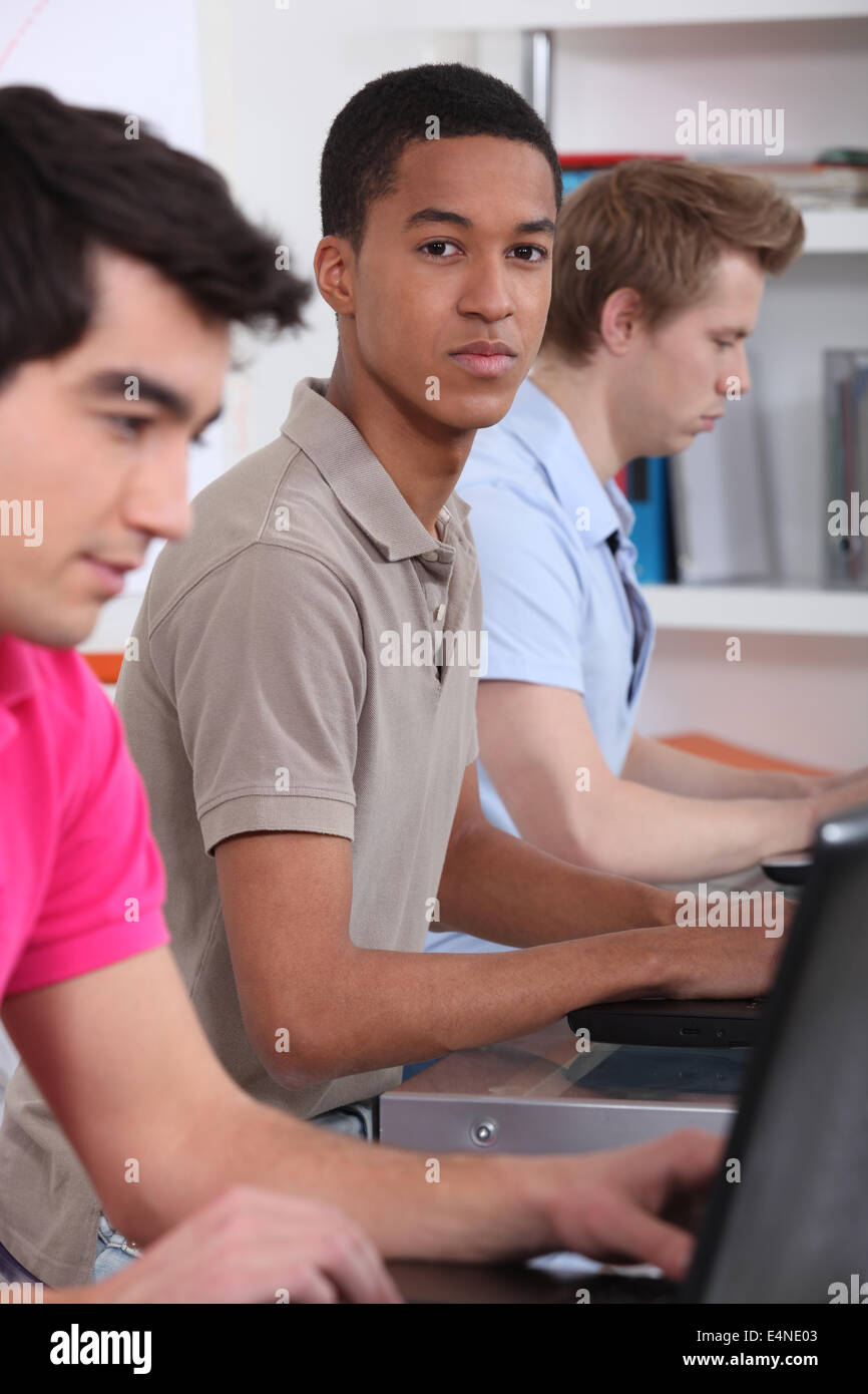 Three students in the library Stock Photo - Alamy