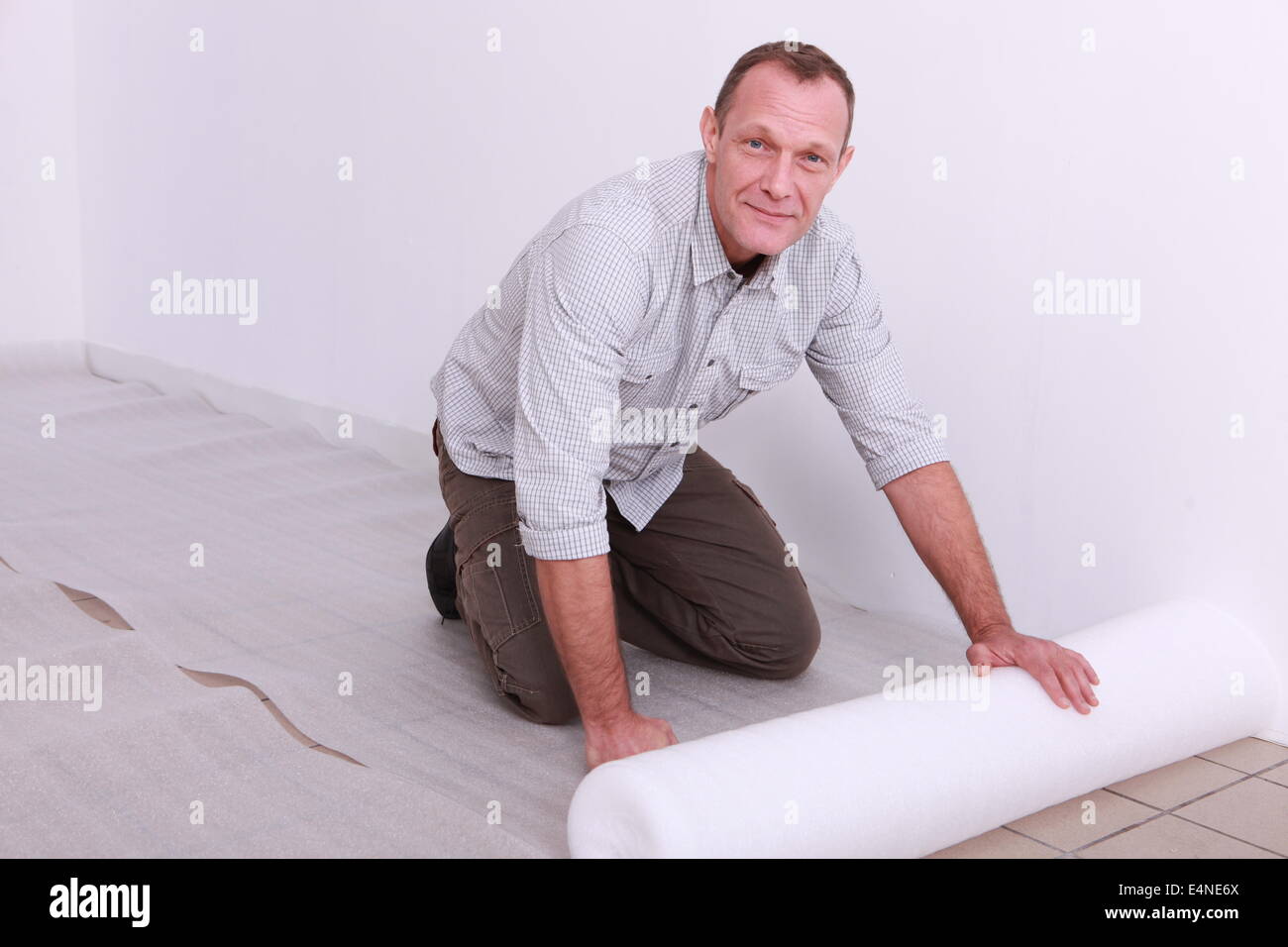 Man putting down underlay Stock Photo - Alamy