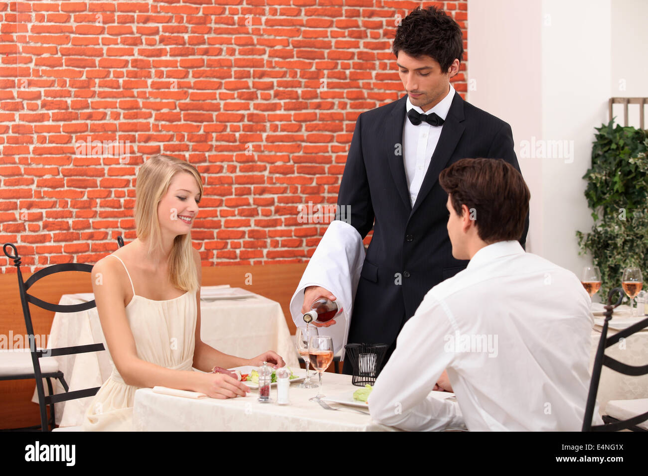 waiter serving couple Stock Photo - Alamy