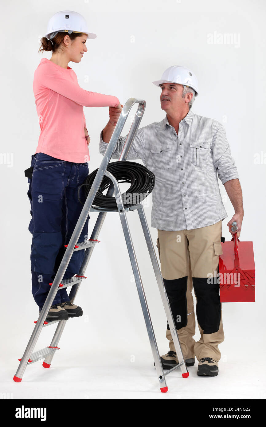 Electrician welcoming female helper Stock Photo - Alamy