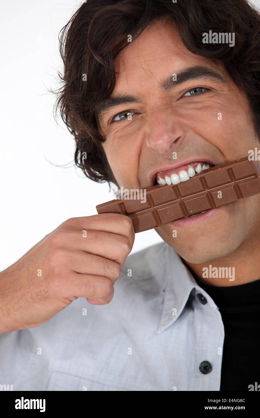 Man eating a bar of chocolate Stock Photo - Alamy