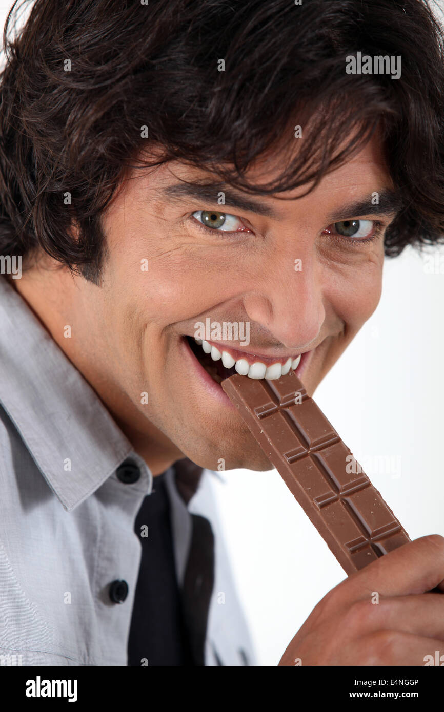 Man eating chocolate bar Stock Photo - Alamy
