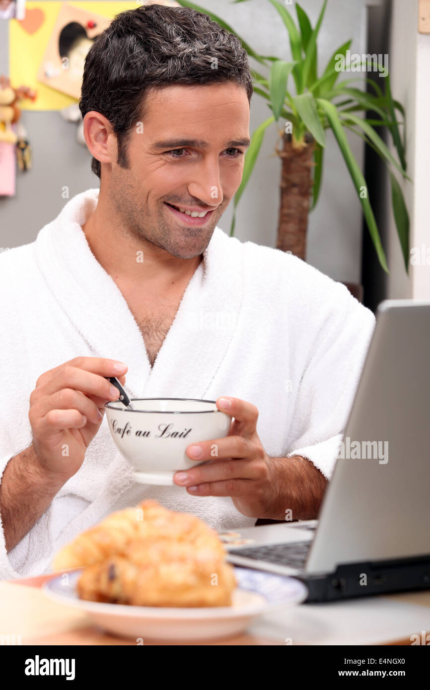 Man having breakfast with computer Stock Photo - Alamy