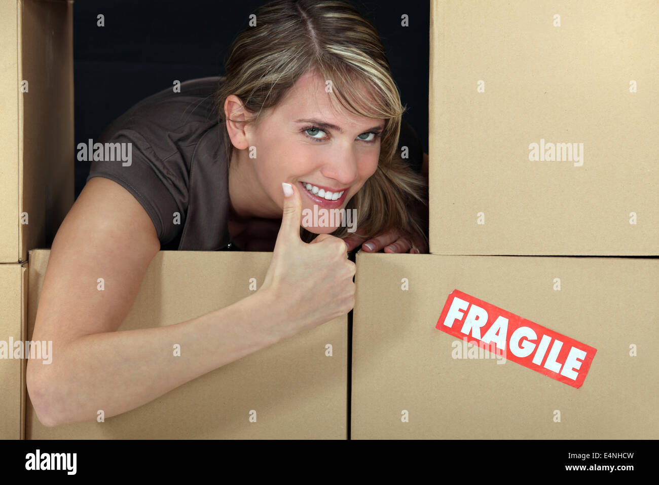 Woman stood amongst fragile boxes Stock Photo - Alamy