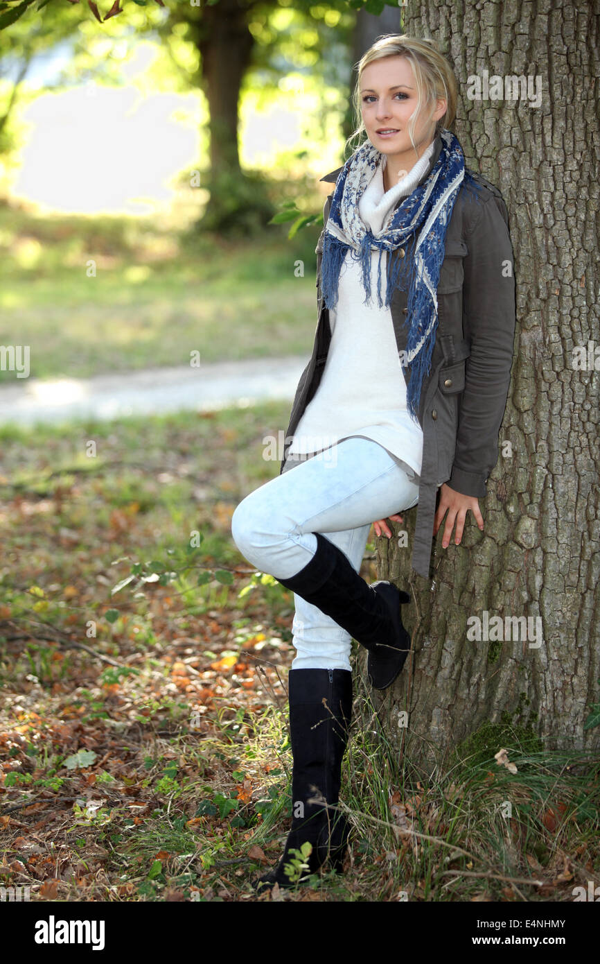 Woman leaning against tree Stock Photo - Alamy