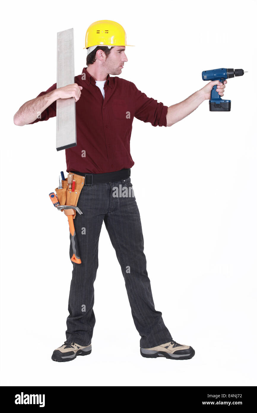 Tradesman holding a girder and a power tool Stock Photo - Alamy